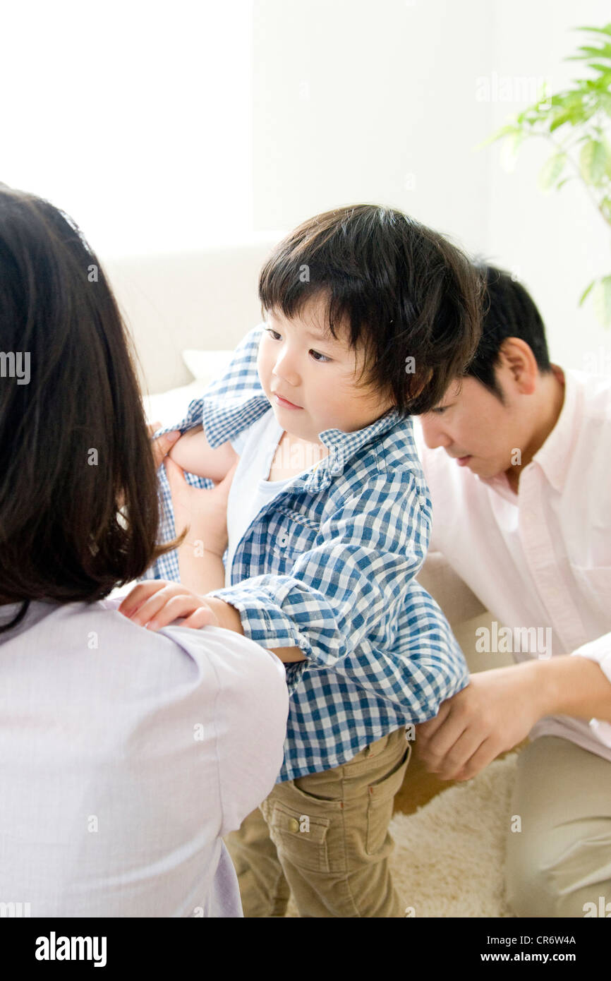 Boy getting dressed with parents Stock Photo - Alamy