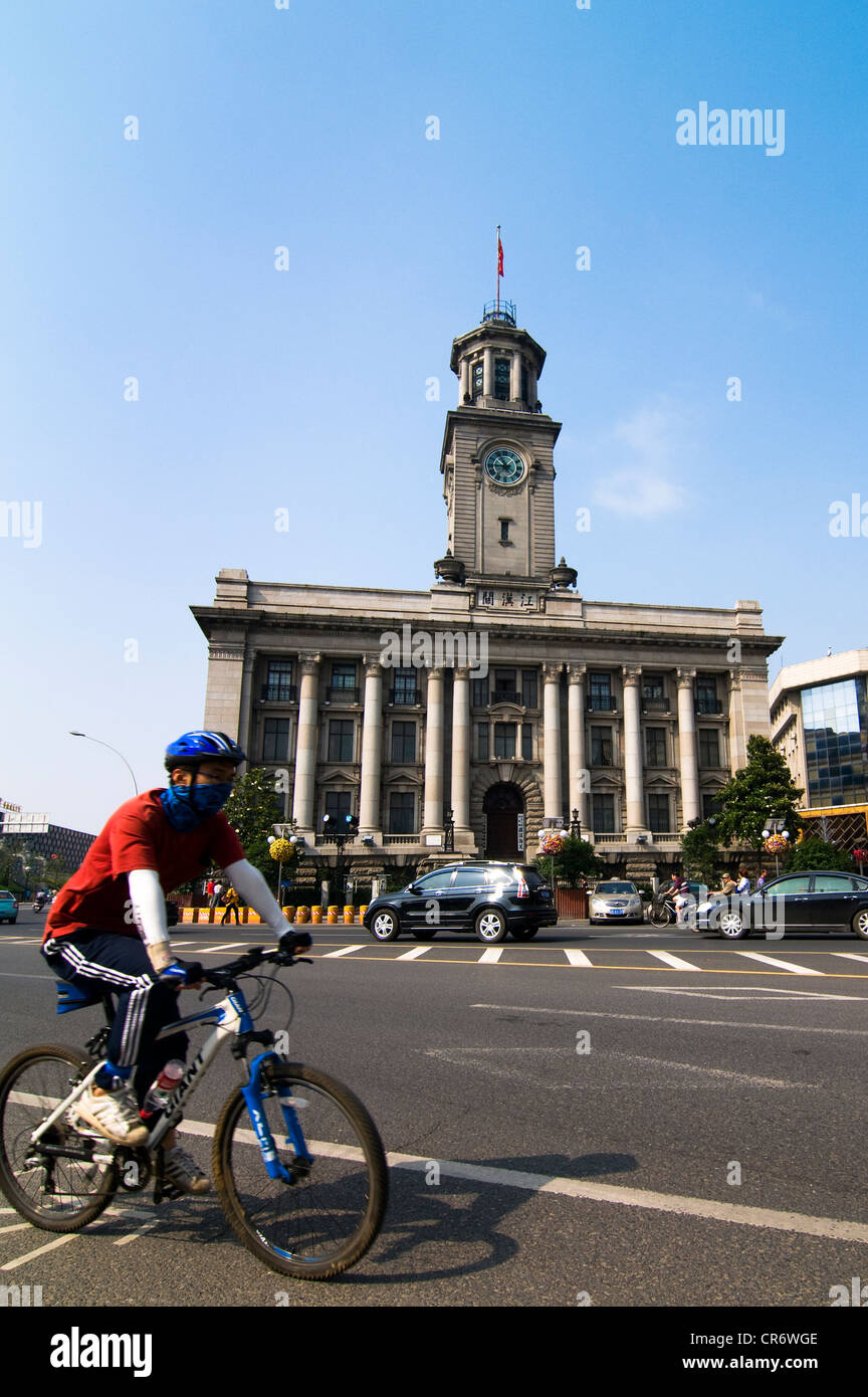 A cyclist passing by the old customs building in the concession area of ...