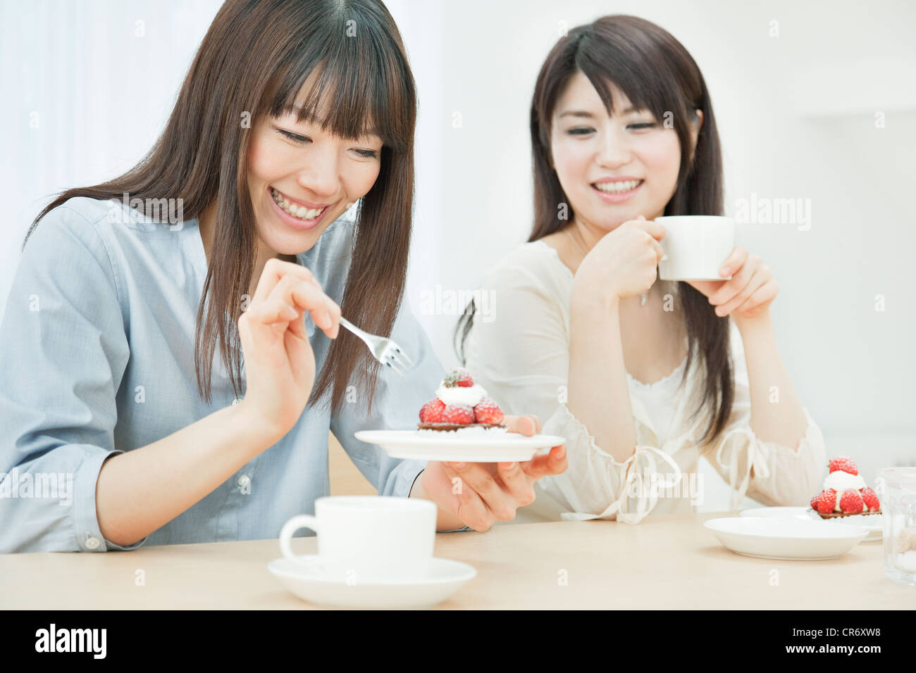 Two friends eating cake Stock Photo - Alamy