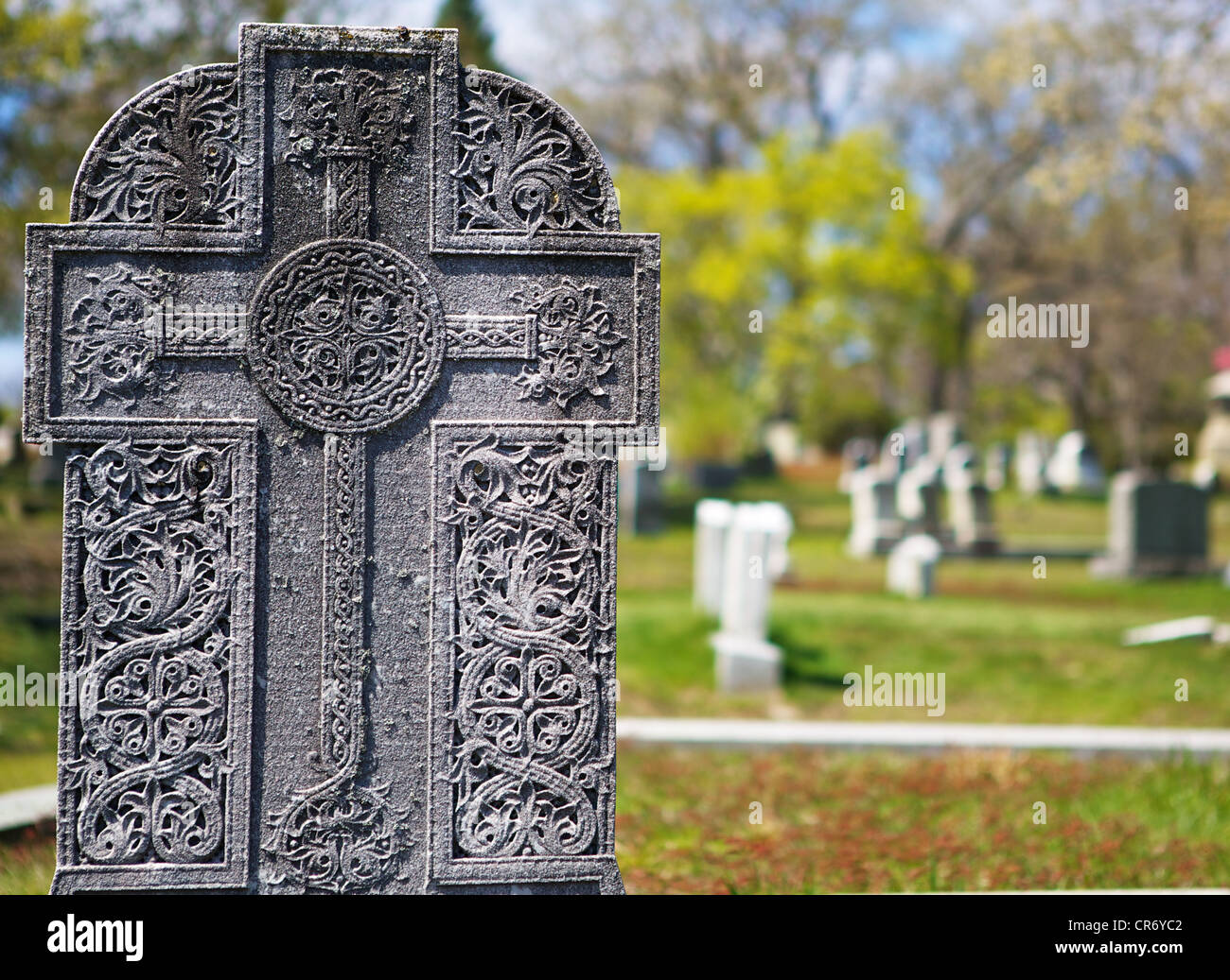 Older worn ornately engraved Celtic design on Cemetery grave stone with ...
