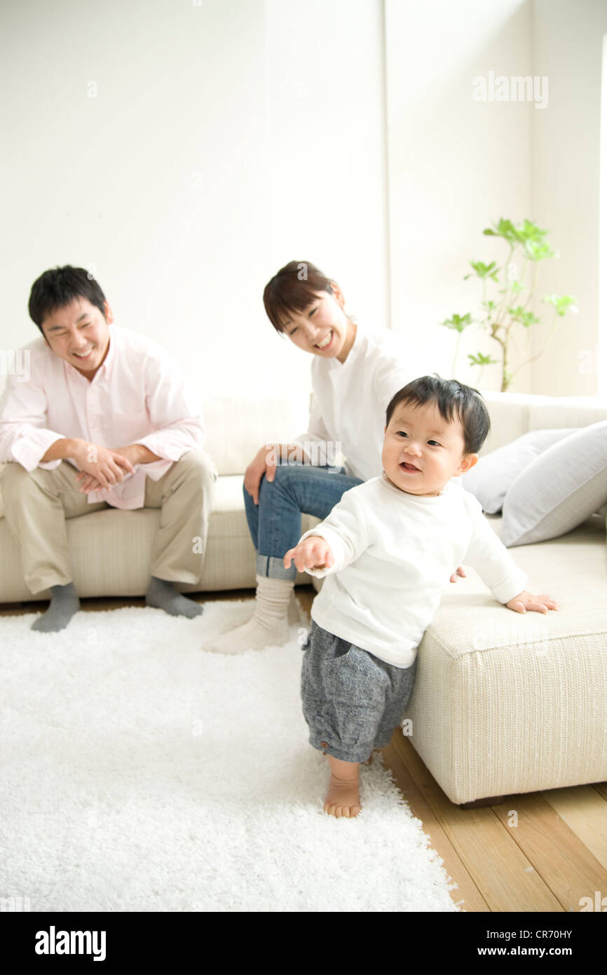 Family of three in living room Stock Photo - Alamy