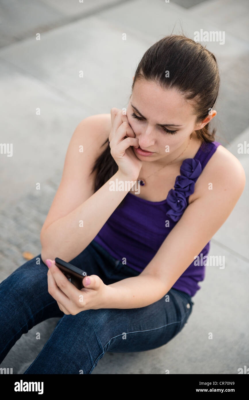 Young worried and nervous woman holding mobile phone Stock Photo - Alamy
