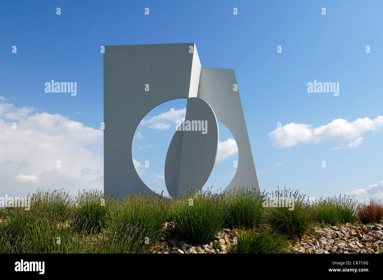 Modern artwork made of white painted steel plates on a traffic island ...