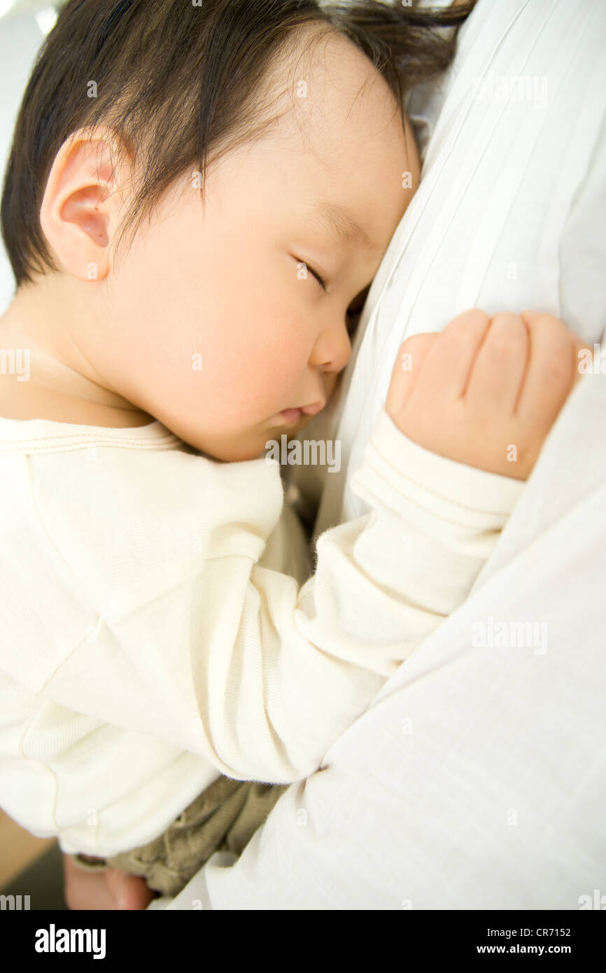Mother and sleeping baby hugging Stock Photo - Alamy