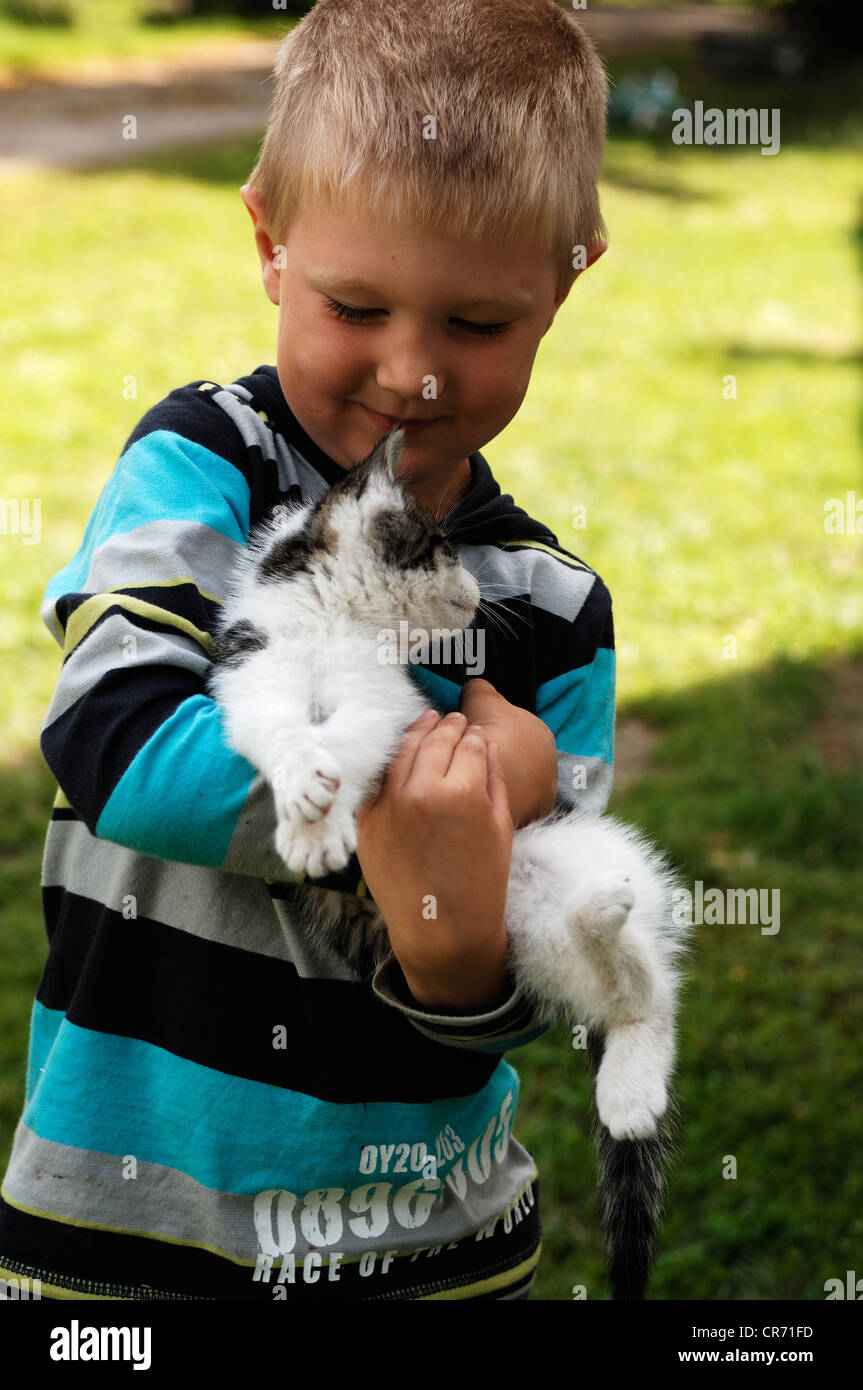 Little boy, 4 years old, carrying a small cat in his arms, Othenstorf ...