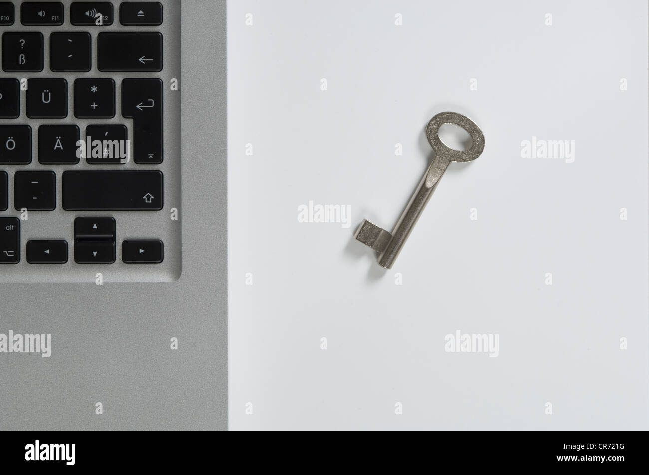 Laptop and key on white background Stock Photo - Alamy