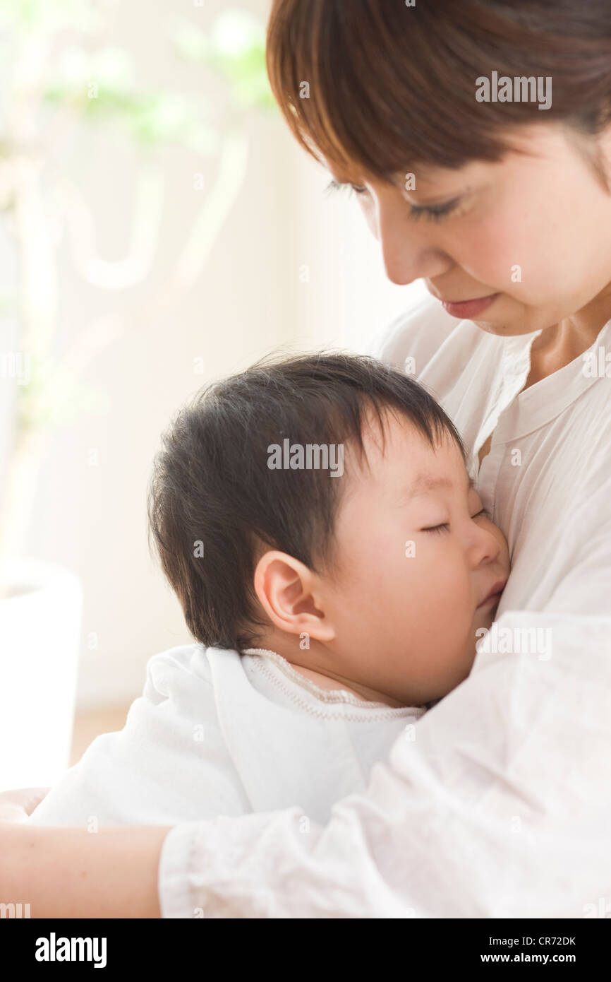 Mother and sleeping baby hugging Stock Photo - Alamy