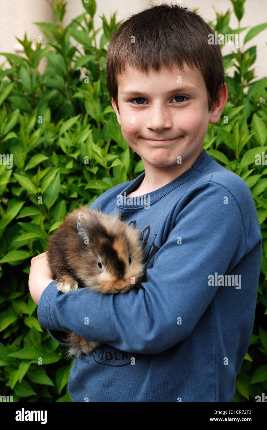 Boy, 6 years, holding his rabbit in his arms with pride Stock Photo - Alamy