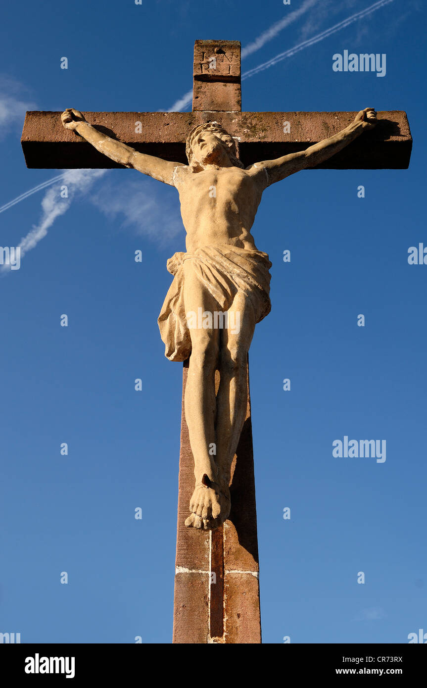 Stone crucifix, 19th Century, against a blue sky in the cemetery of ...