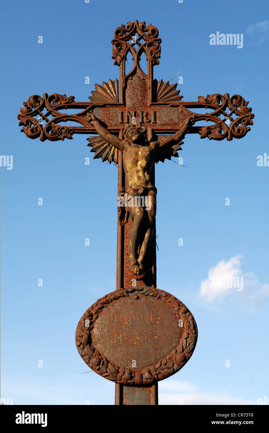 Rusted cast-iron crucifix, 19th Century, against a blue sky in the ...