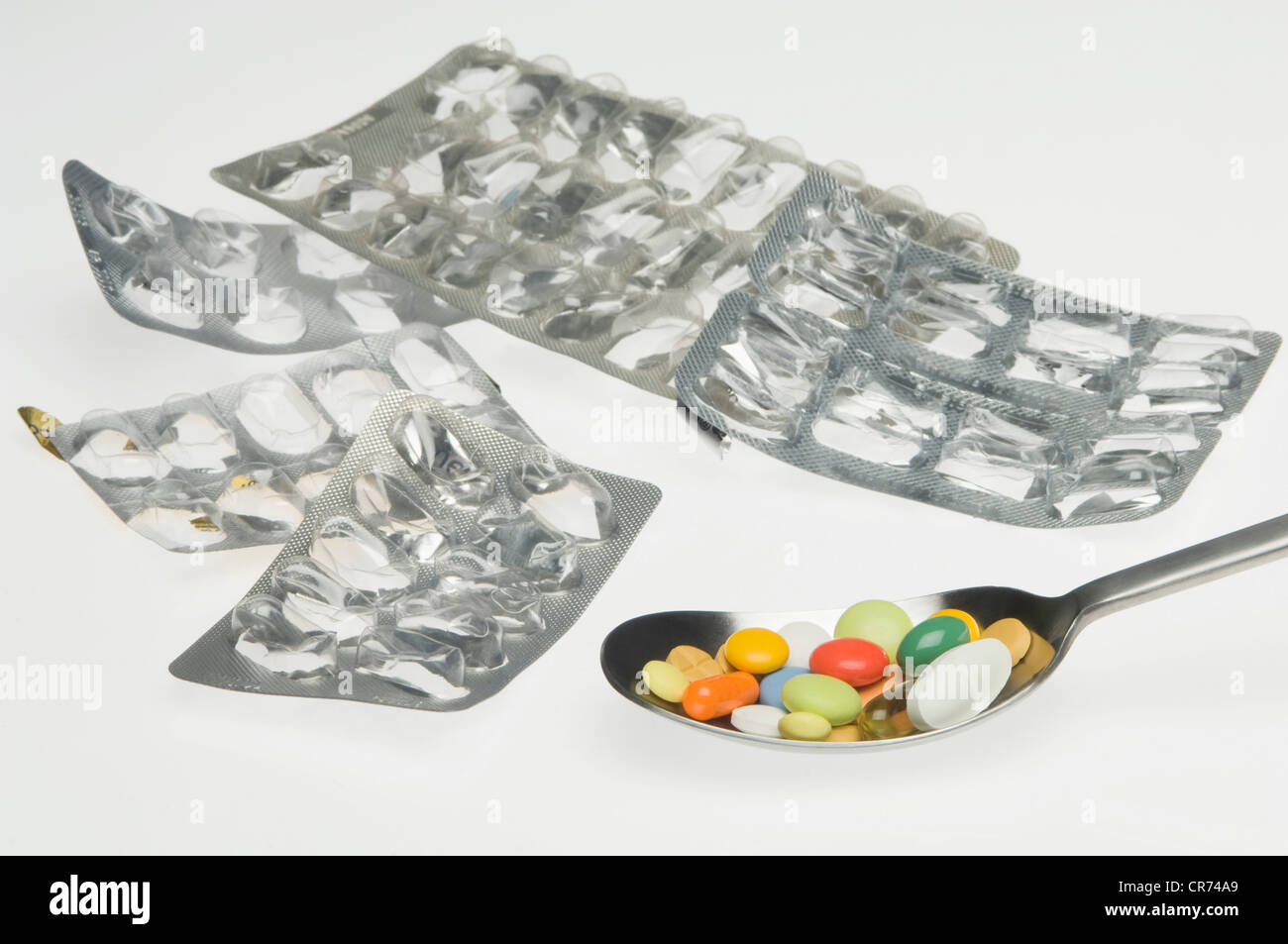 Empty blister pack with spoon full of medicines on white background ...