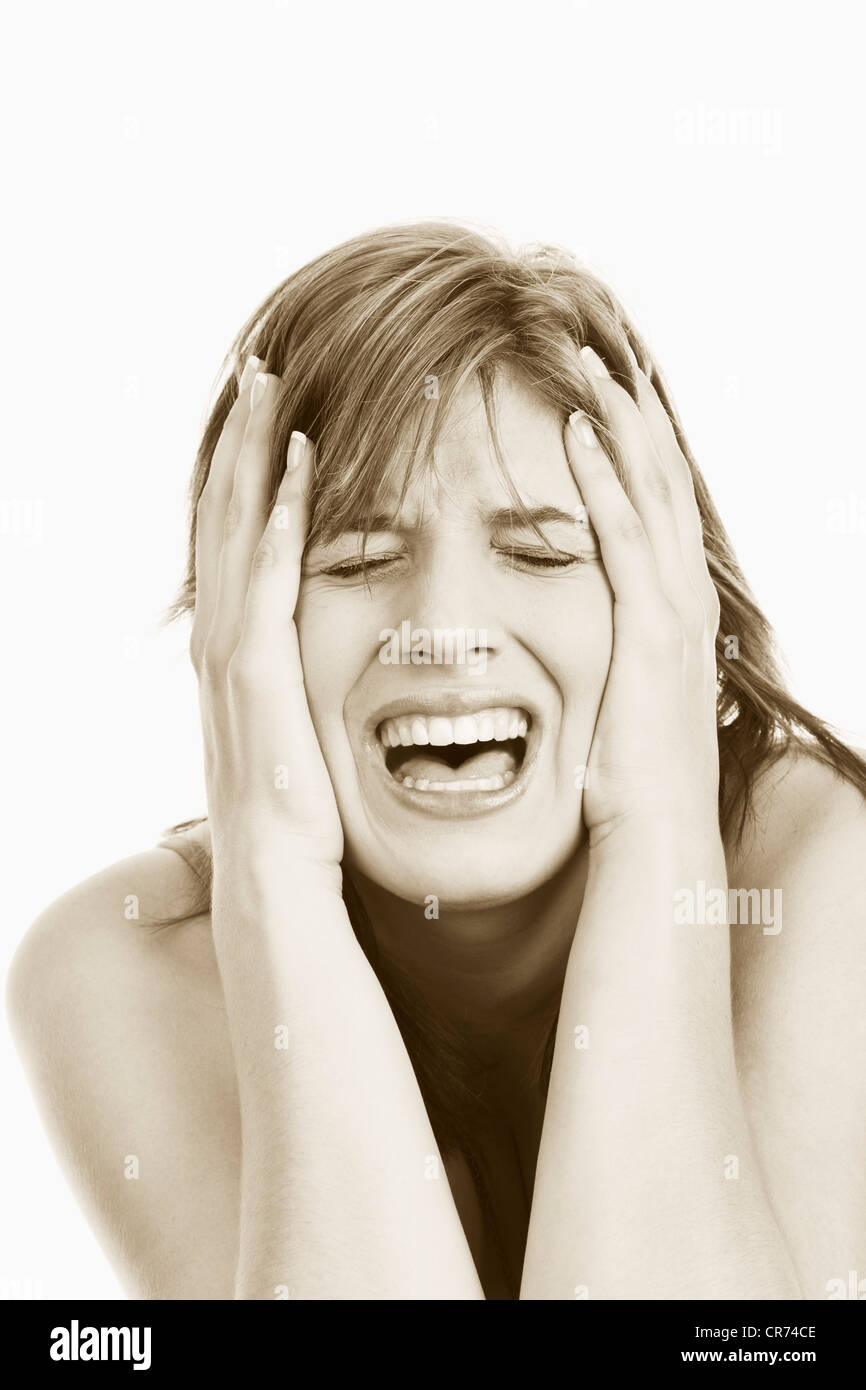 Young woman with head in hand, screaming Stock Photo - Alamy