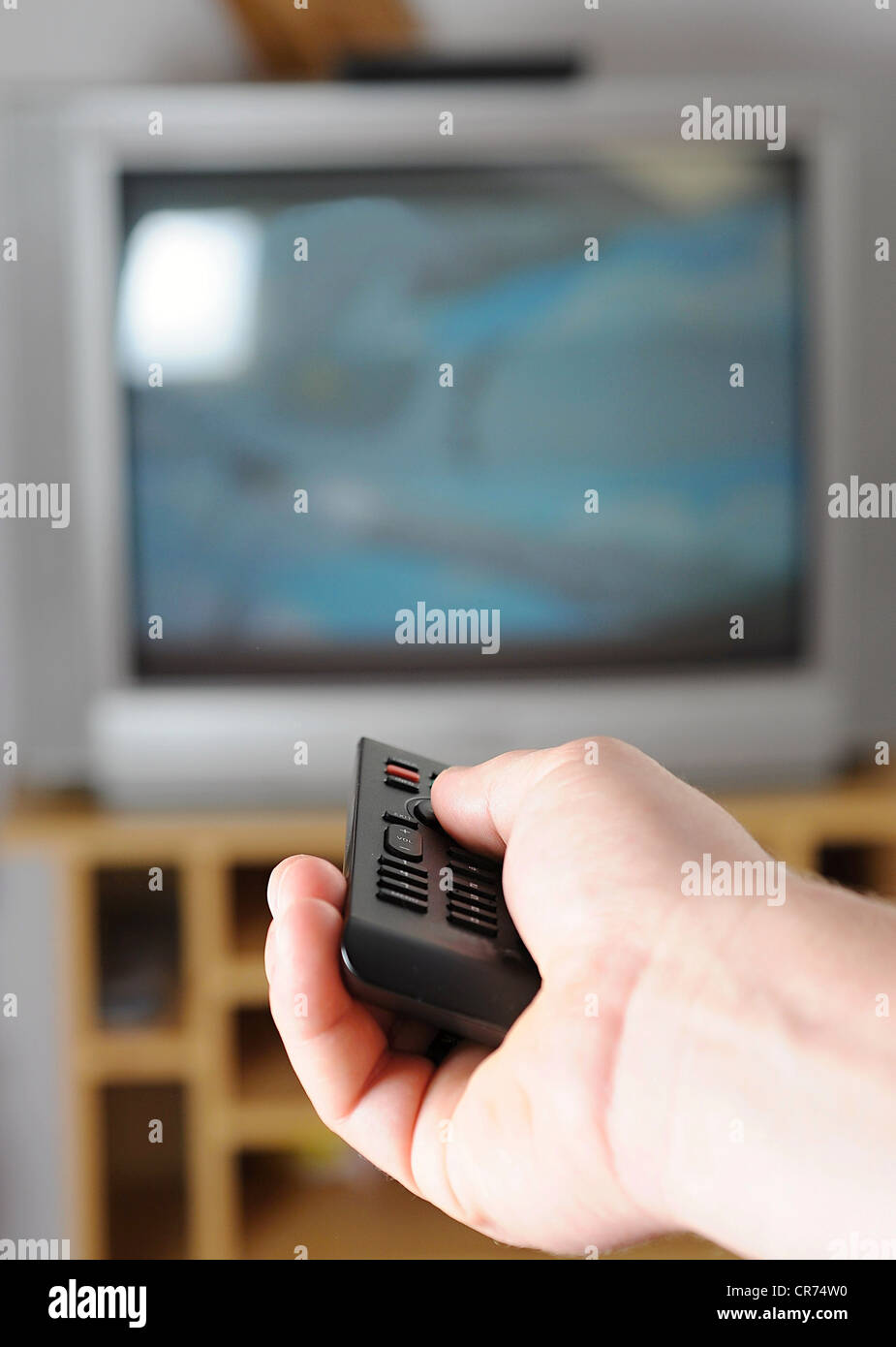 Hand with TV remote controller change the TV channel Stock Photo - Alamy