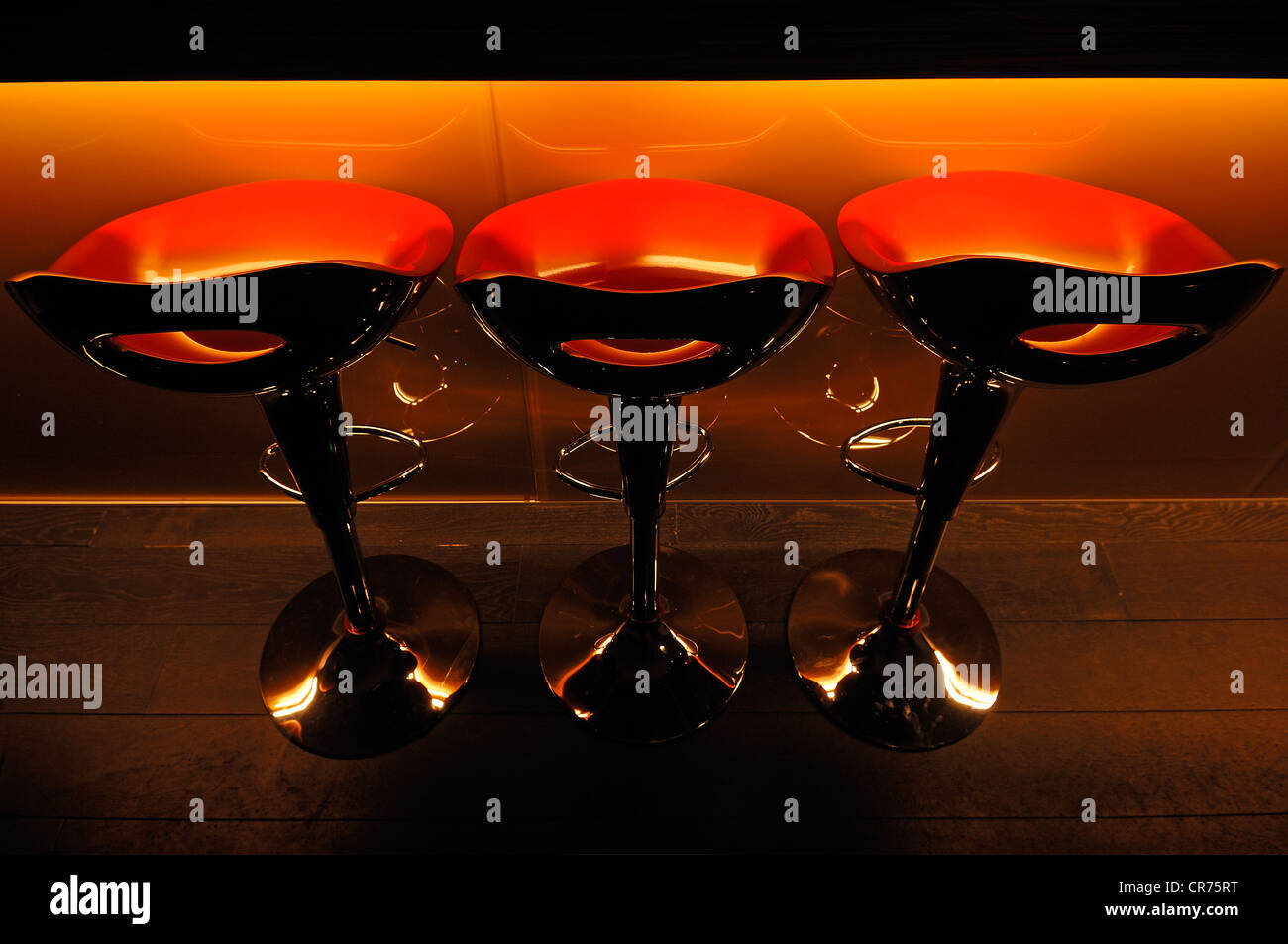 Three red plastic bar stools in front of a bar at a school of hotel ...