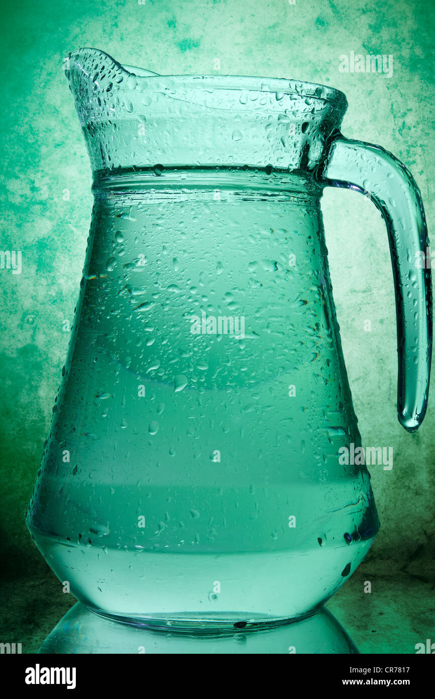 water in a glass pitcher on dark dirty background Stock Photo - Alamy