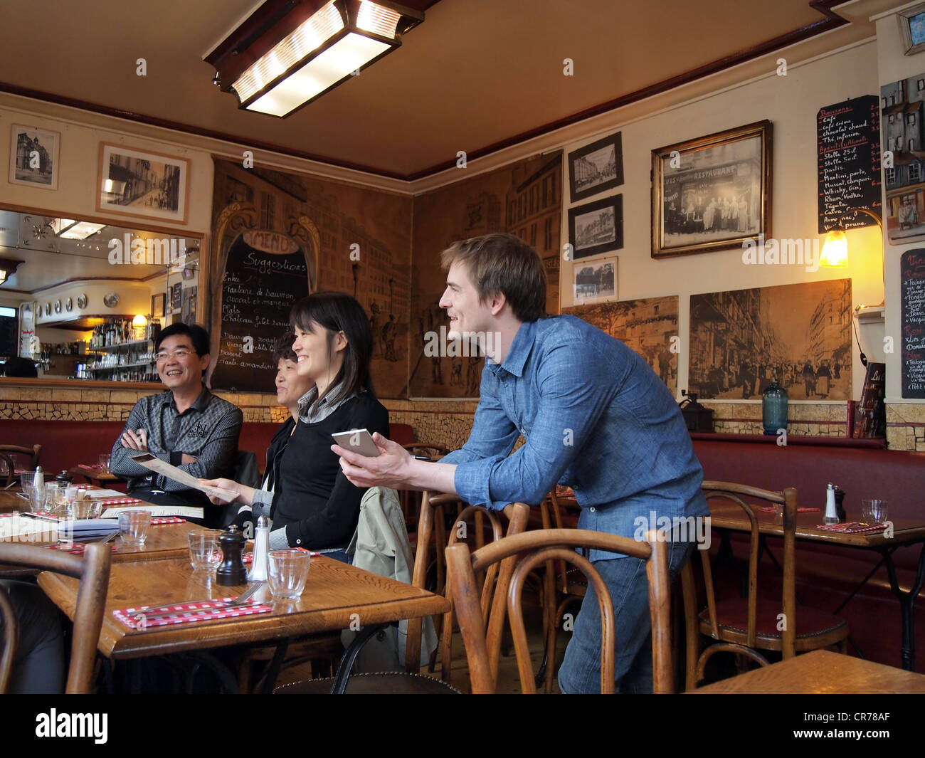 Customers and waiter at a restaurant in the Marais district, Paris ...