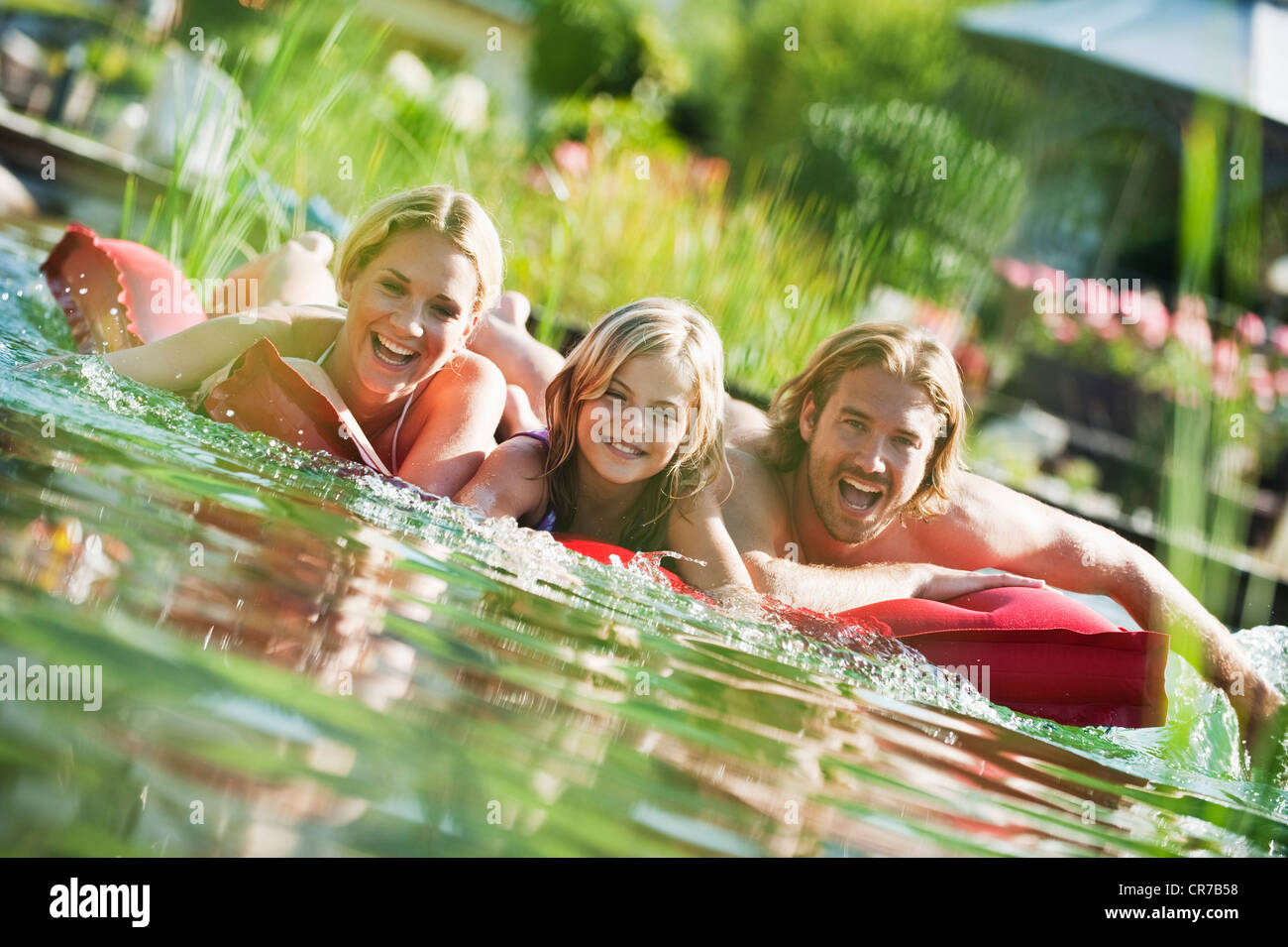 Austria, Salzburg County, Family on airbed in natural pool Stock Photo ...
