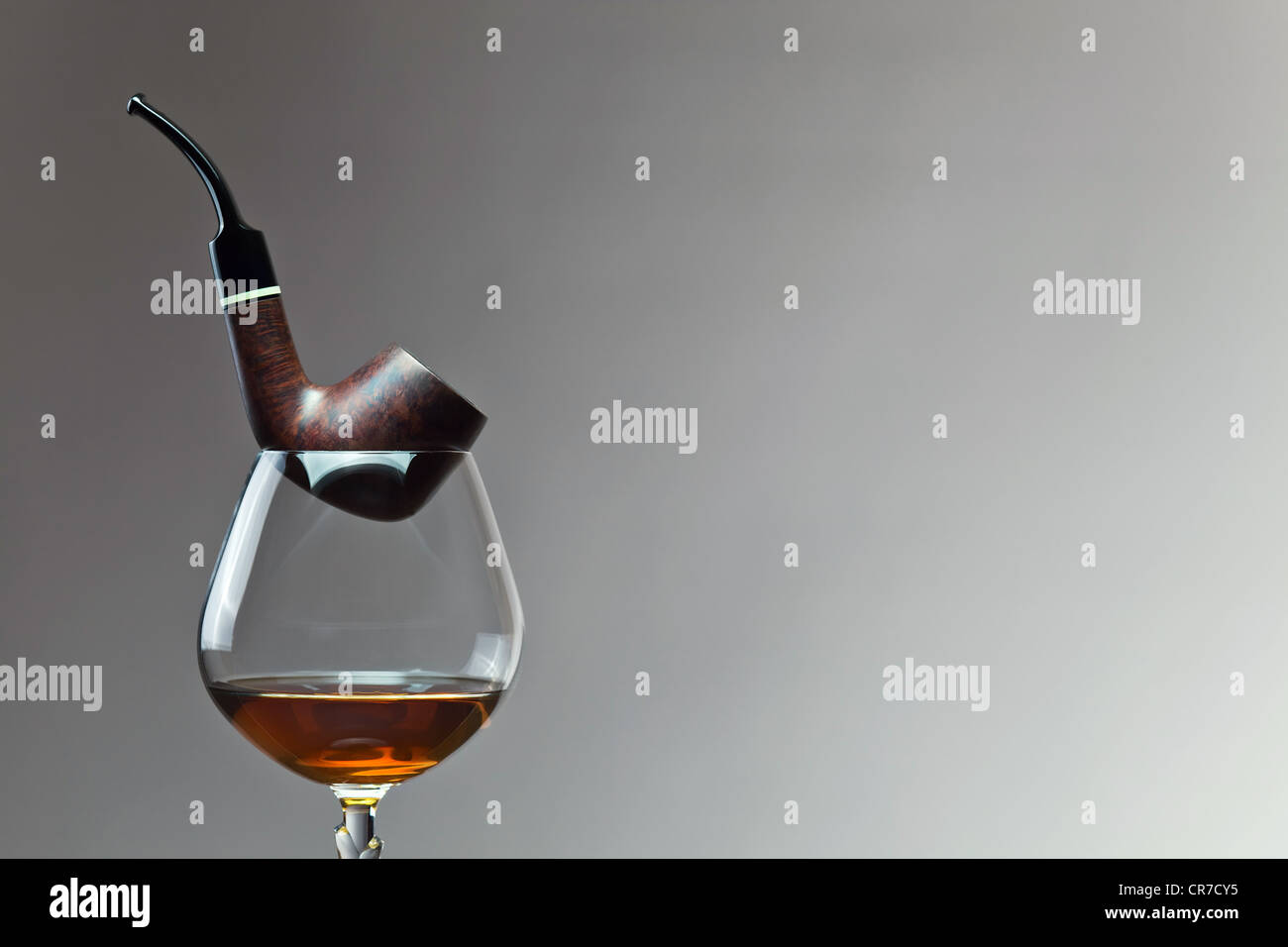cognac and pipe on a grey background Stock Photo - Alamy