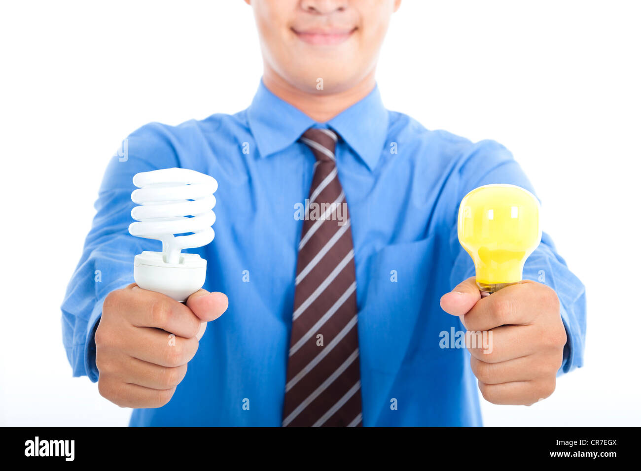 smiling businessman holding energy saving light bulb and tradition ...