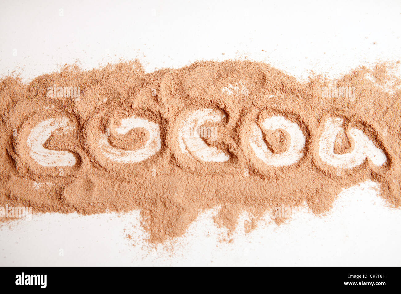 The word 'cocoa' spelt out using cocoa powder on an off-white ...