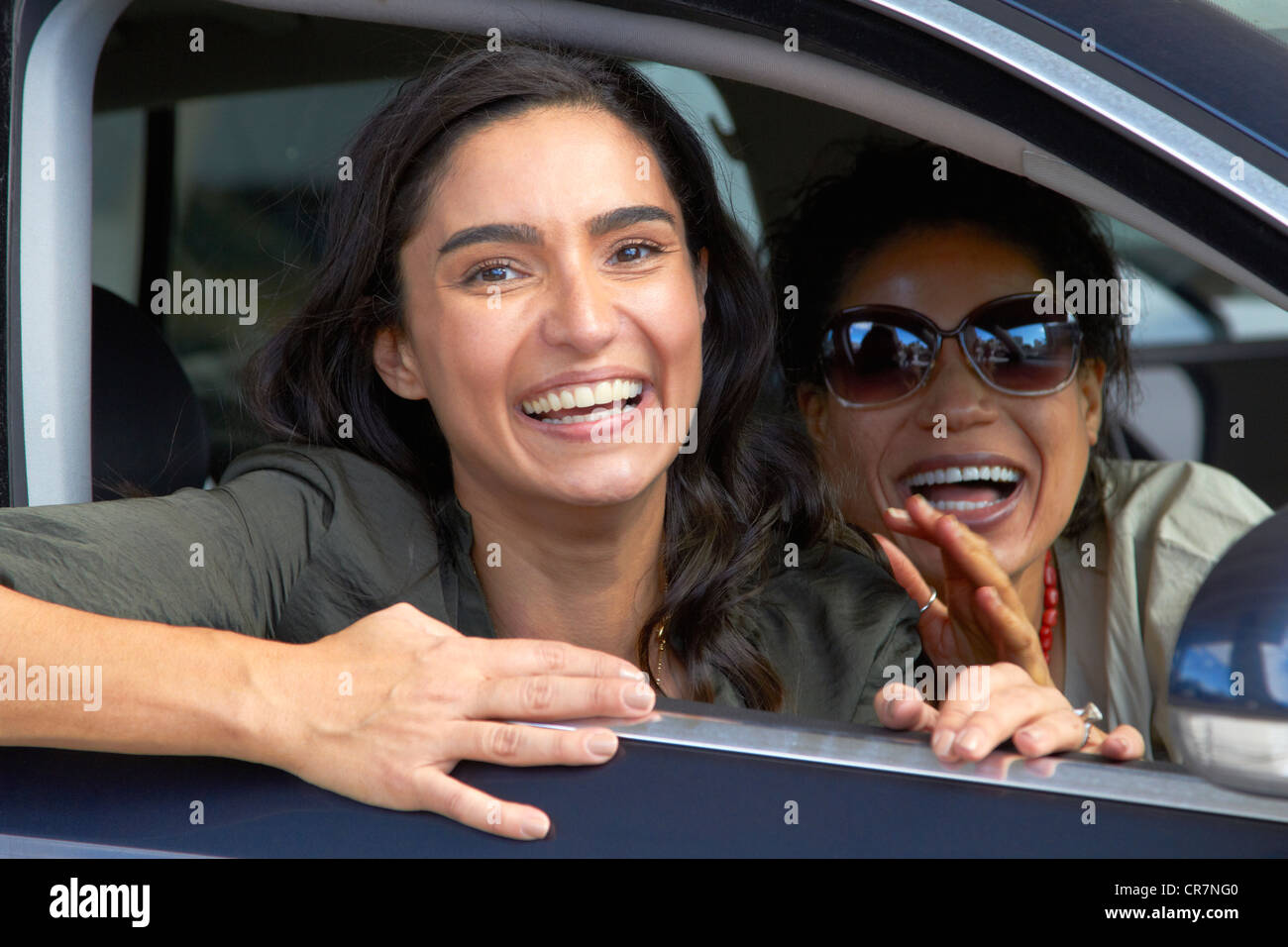 Smiling friends driving in car Stock Photo - Alamy