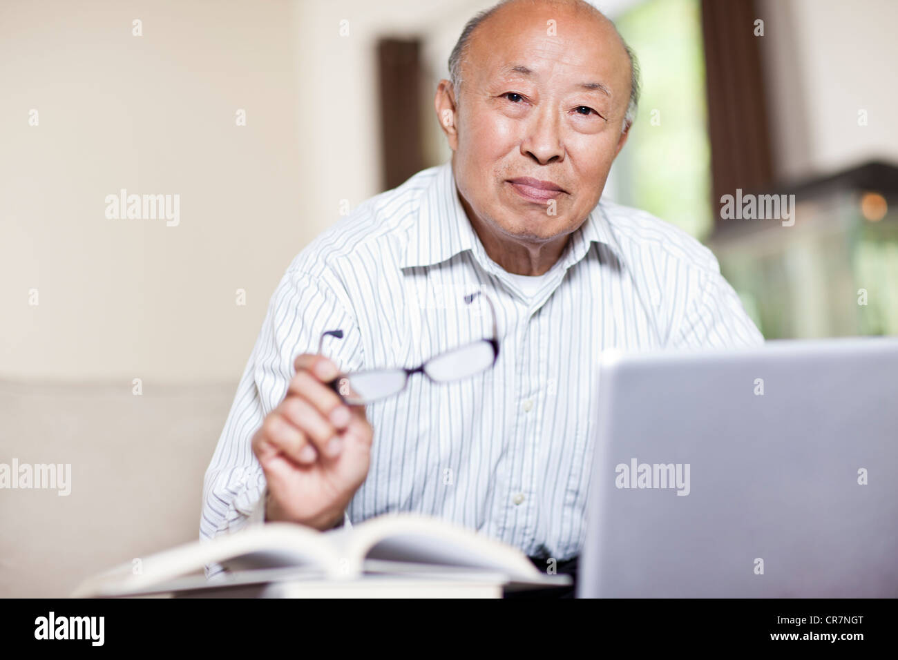 Chinese man with book and laptop Stock Photo - Alamy