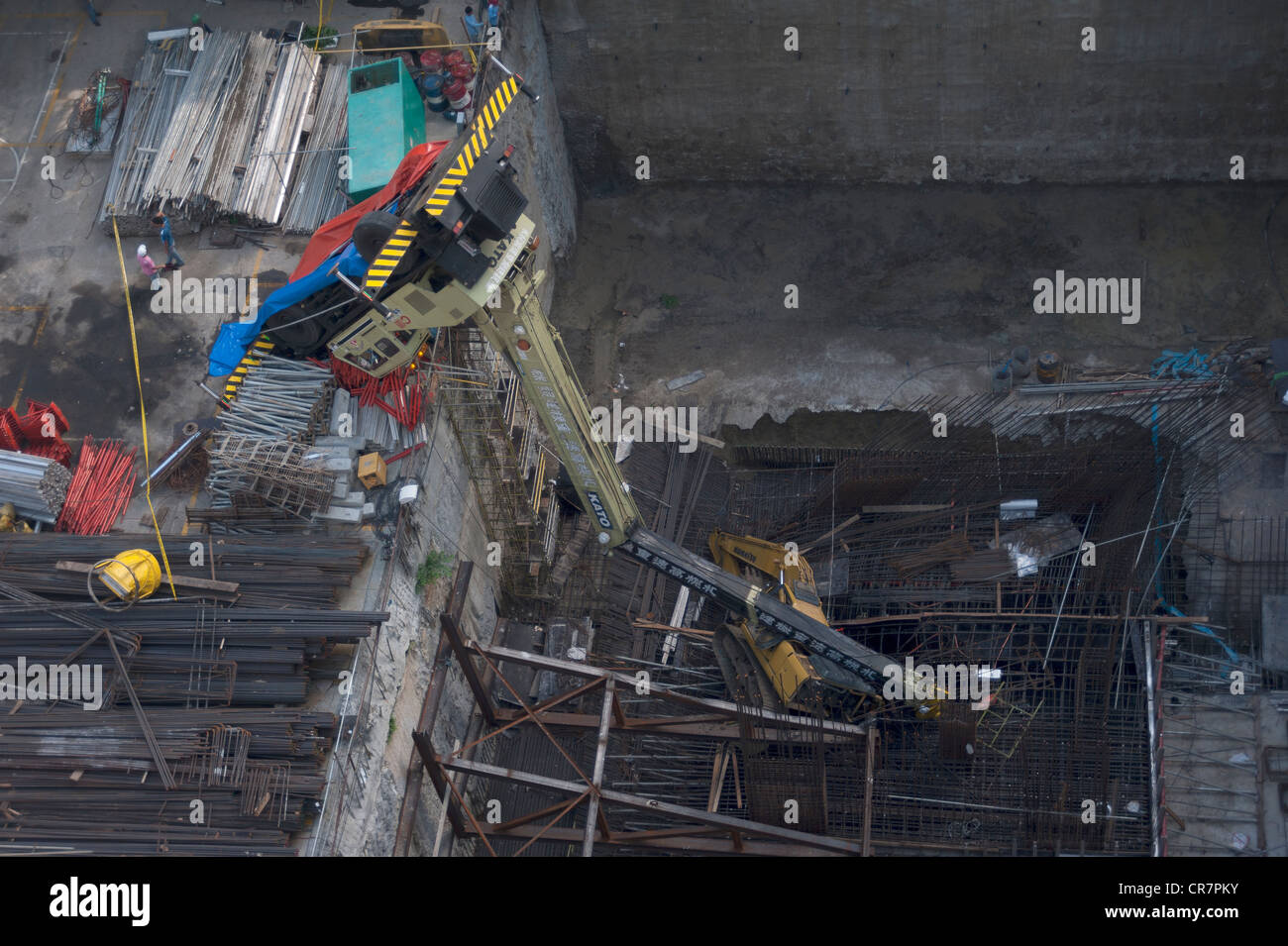 Crane trying to lift excavator out of Philippine construction site ...