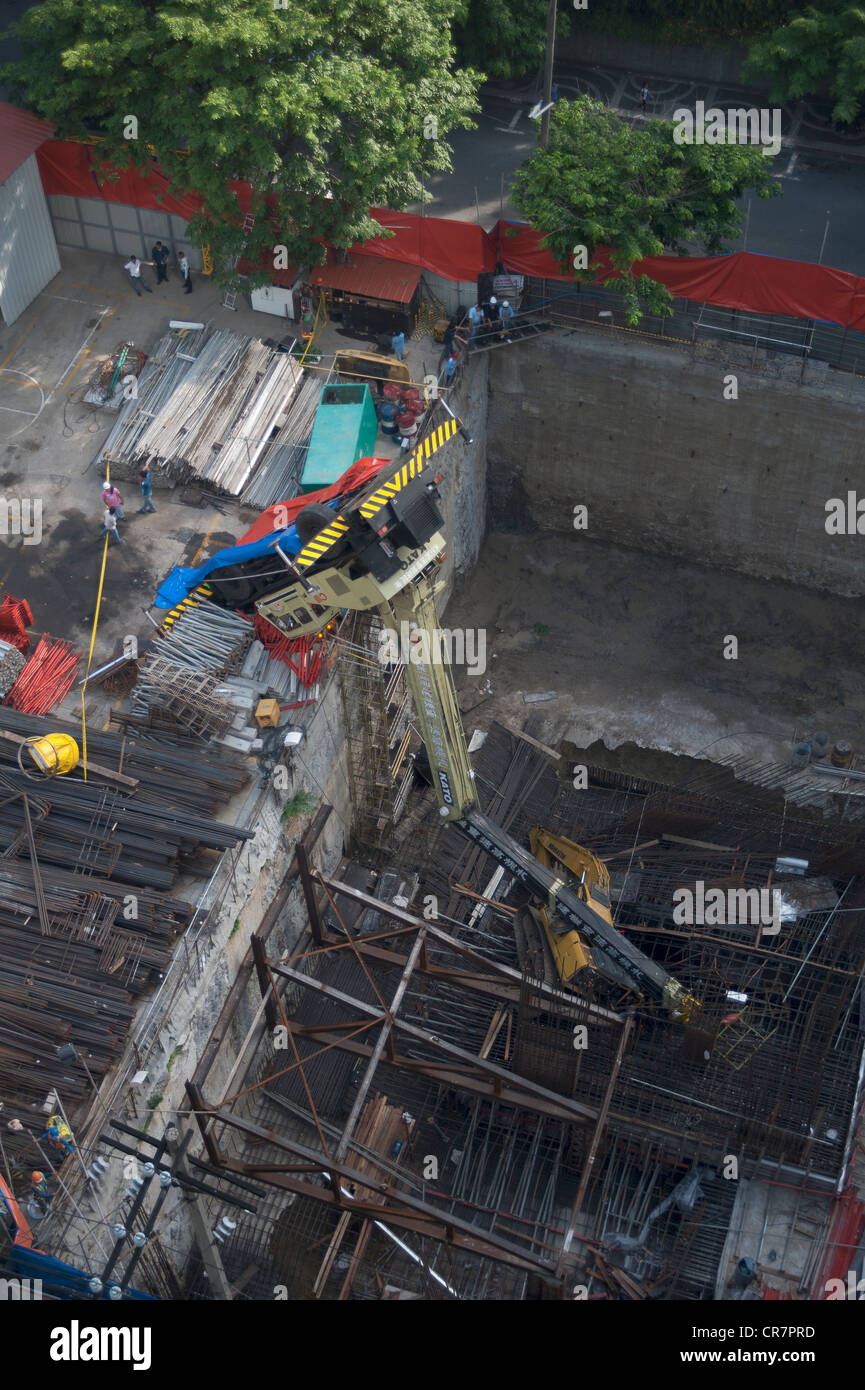 Crane trying to lift excavator out of Philippine construction site ...