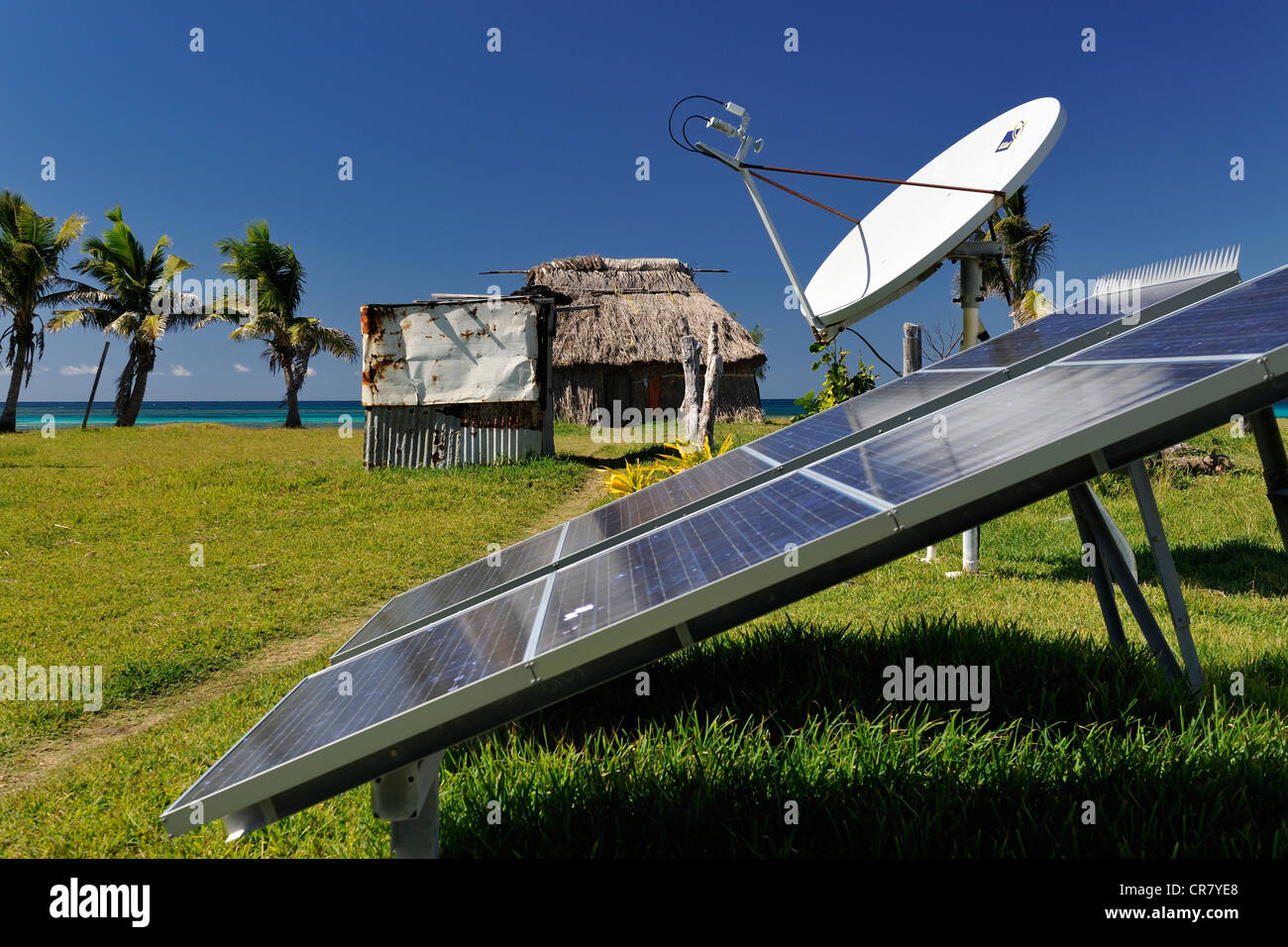Satellite dish, solar power and thatched and corrugated roofed huts in ...