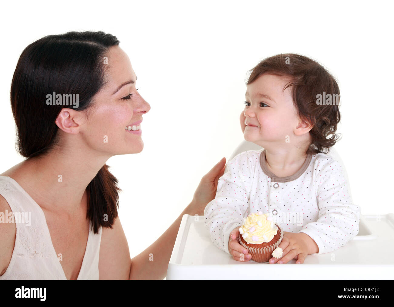 Baby looking at mum with cheeky face and cupcake Stock Photo - Alamy