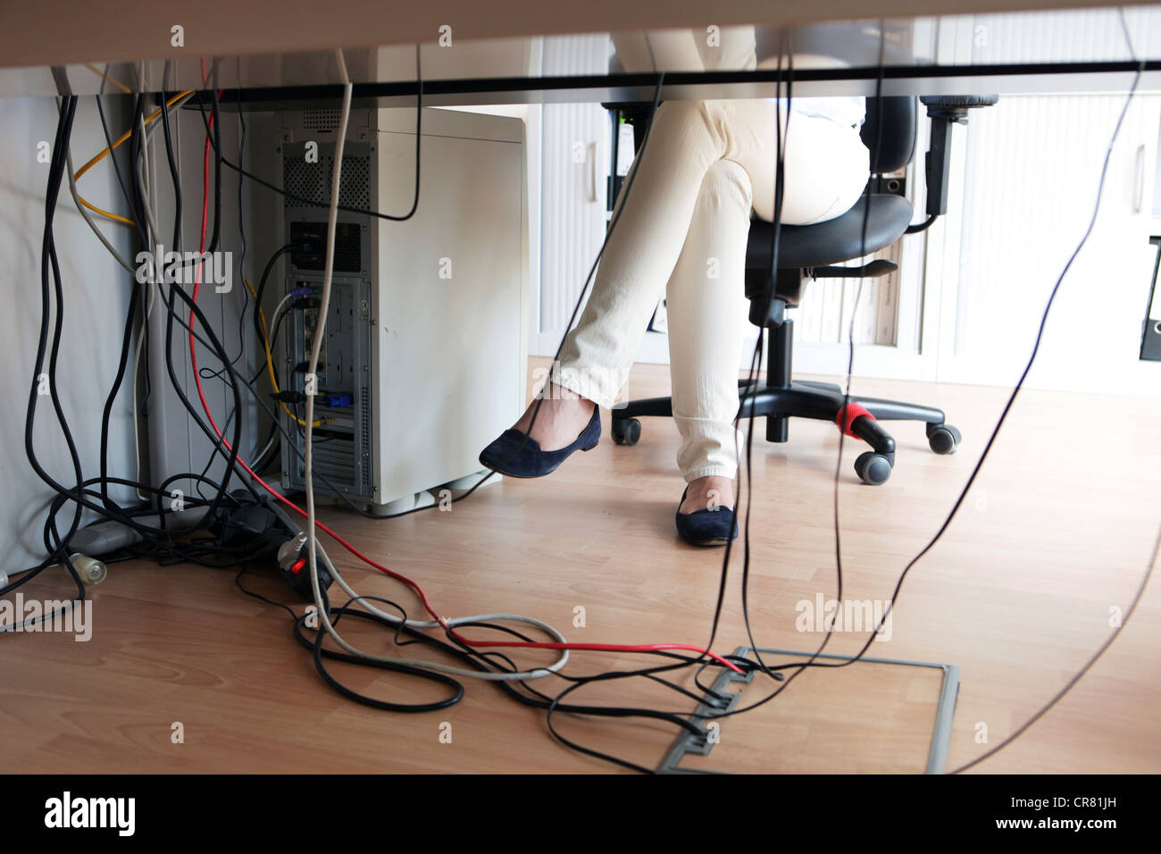 Cables under the desk in an office Stock Photo - Alamy
