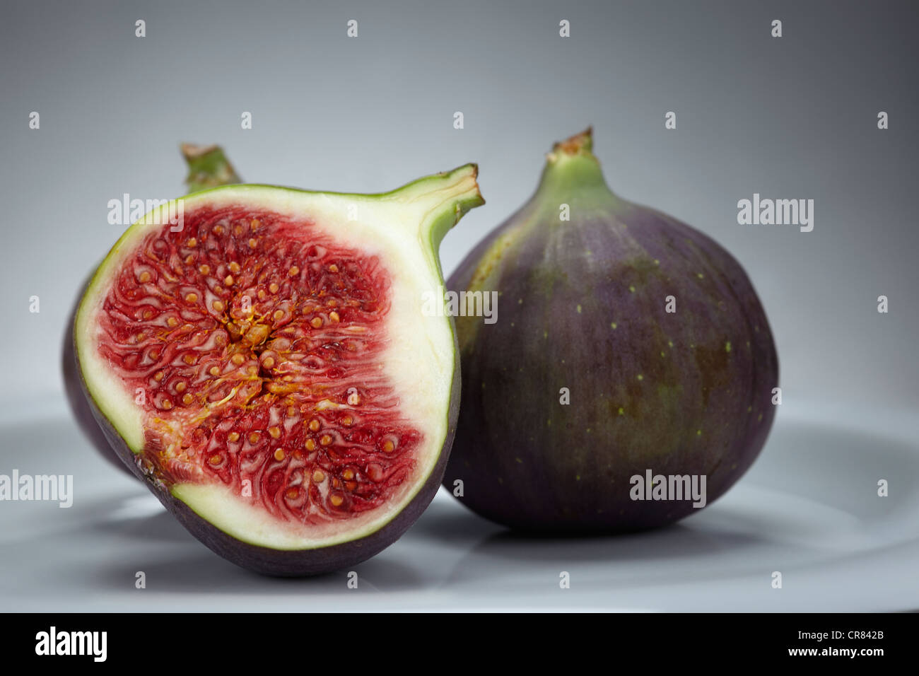 Blue figs (Ficus carica) on a white plate Stock Photo - Alamy