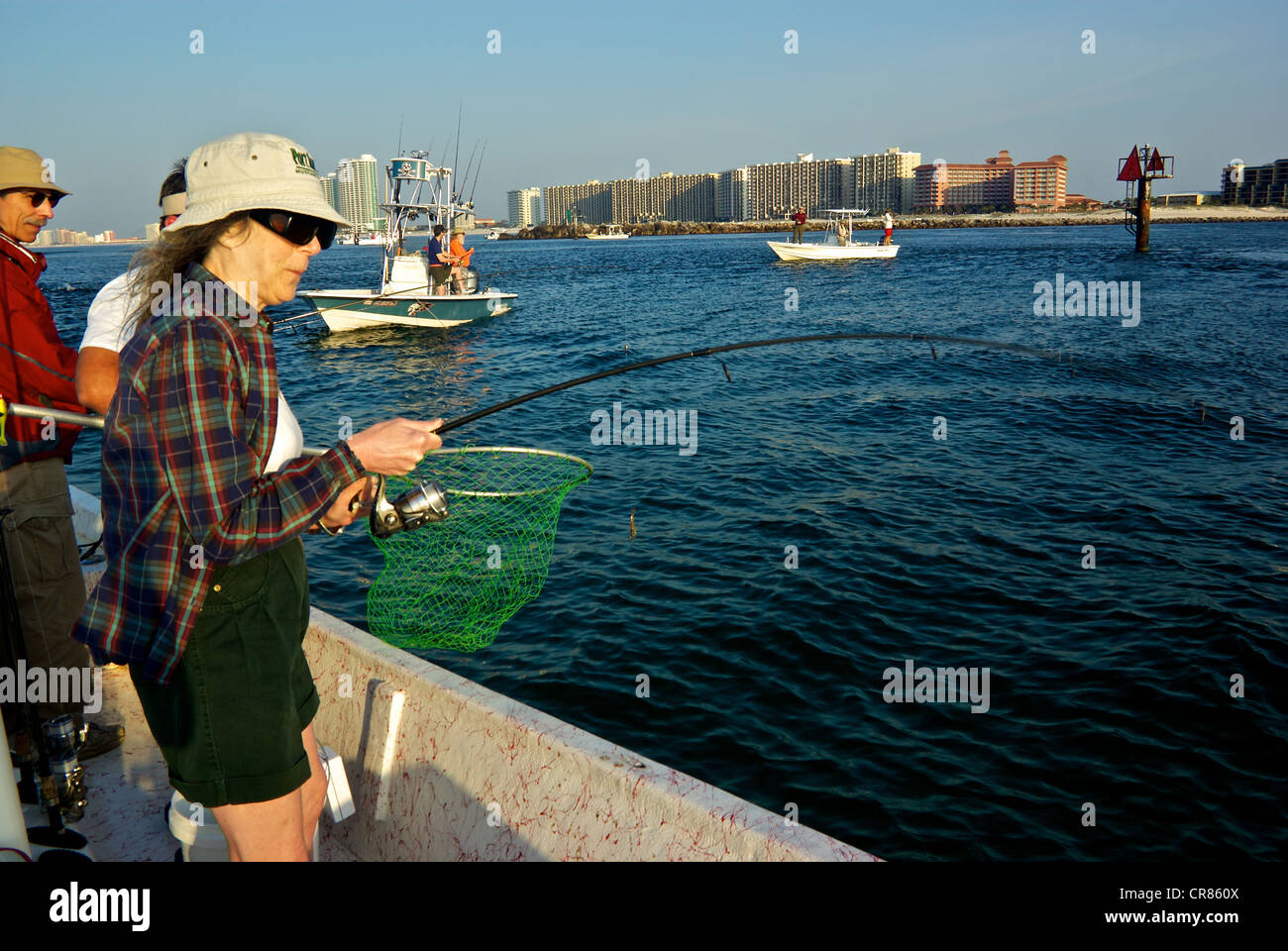 Female sport angler playing fish light spinning rod tip in motion blur ...