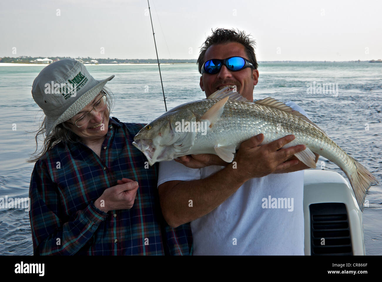 Female sport angler admiring redfish inshore saltwater game fish that ...