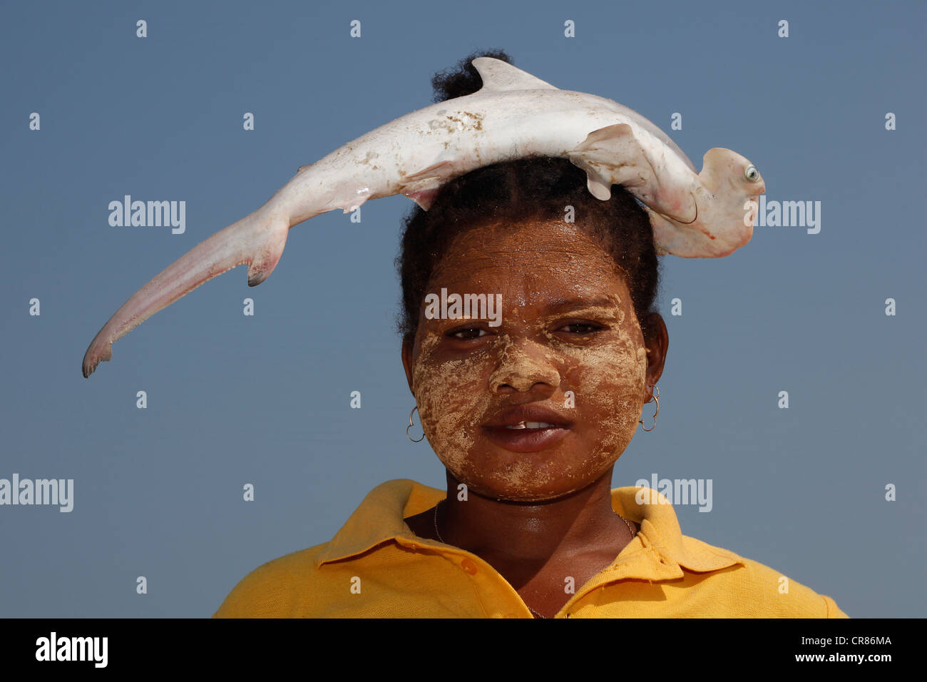 Fishwife carrying a small hammerhead shark on her head, Morondava ...