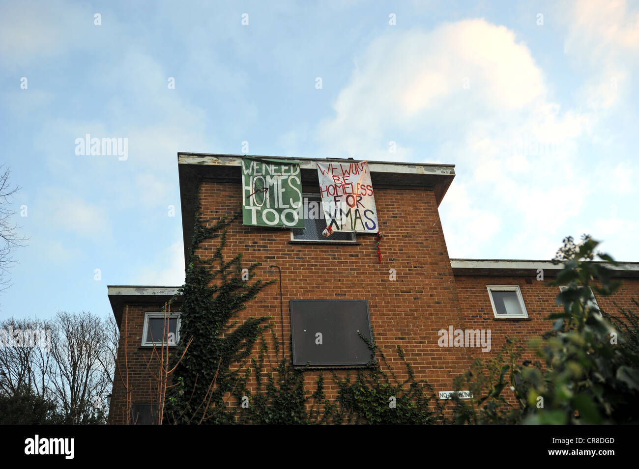 Squatters hang signs on the roof of a house they are staying in over ...