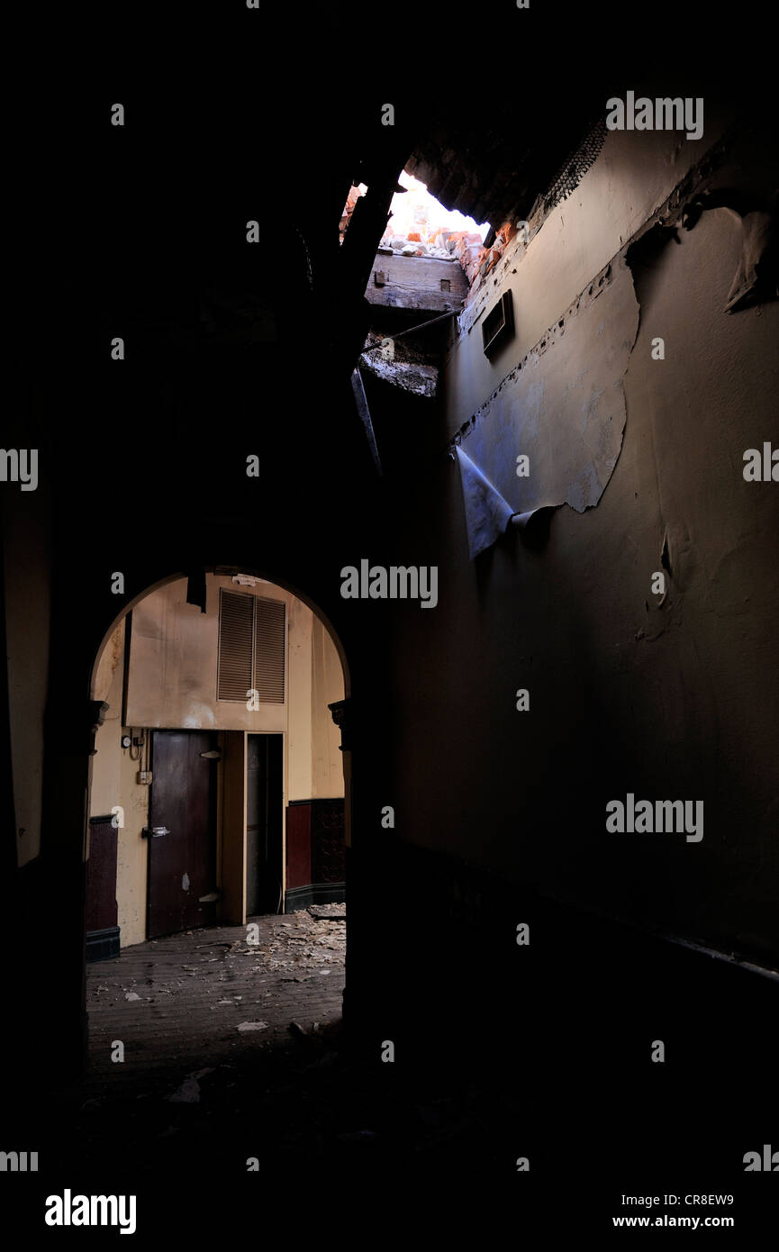 Interior of fire-damaged building with partially collapsed ceiling ...