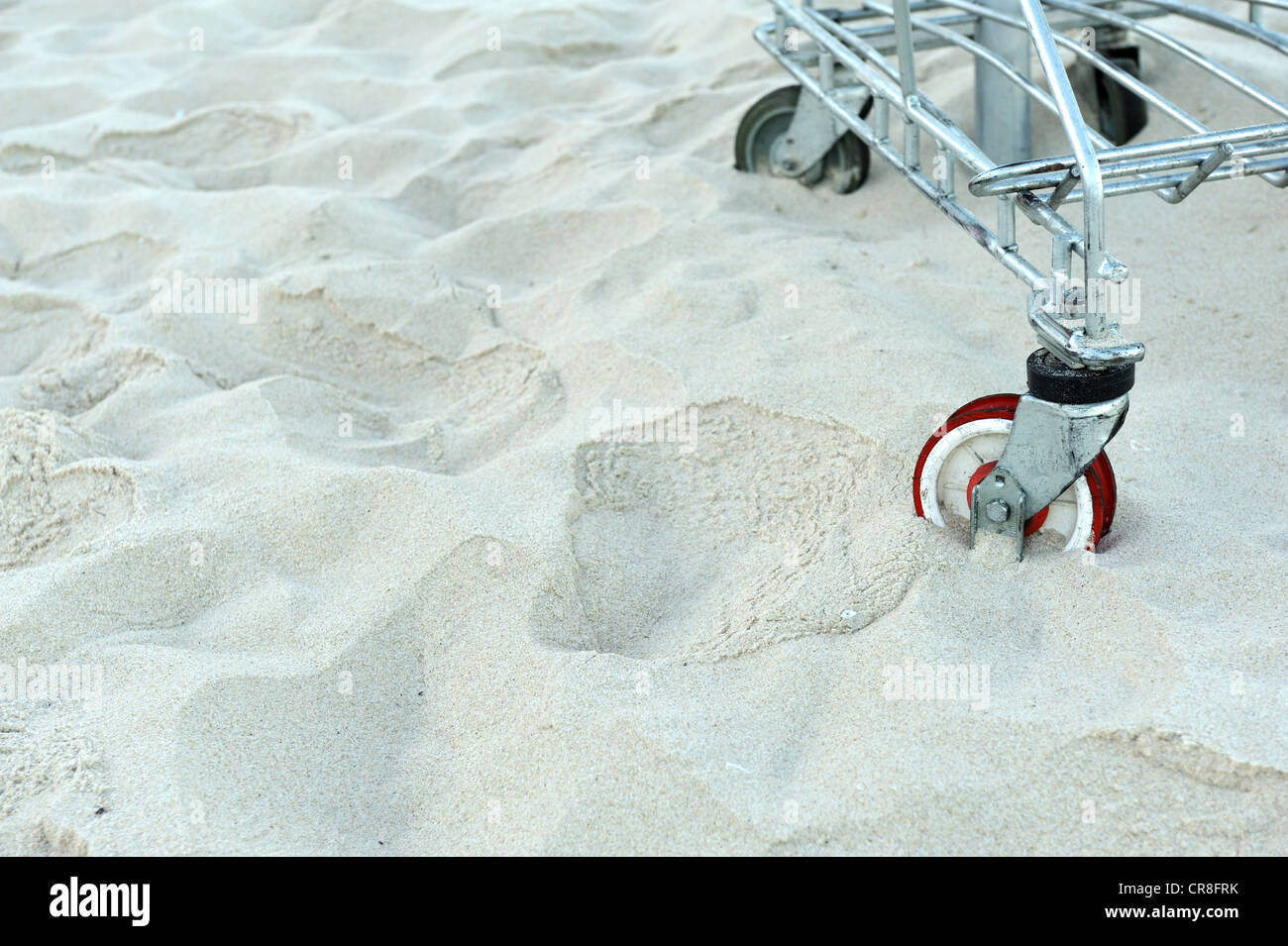 Wheel of shopping trolley stuck in deep beach sand Stock Photo - Alamy