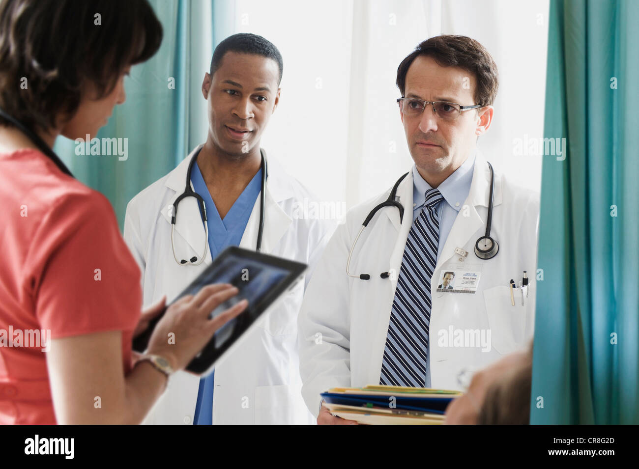 Doctors in discussion with nurse in hospital Stock Photo - Alamy