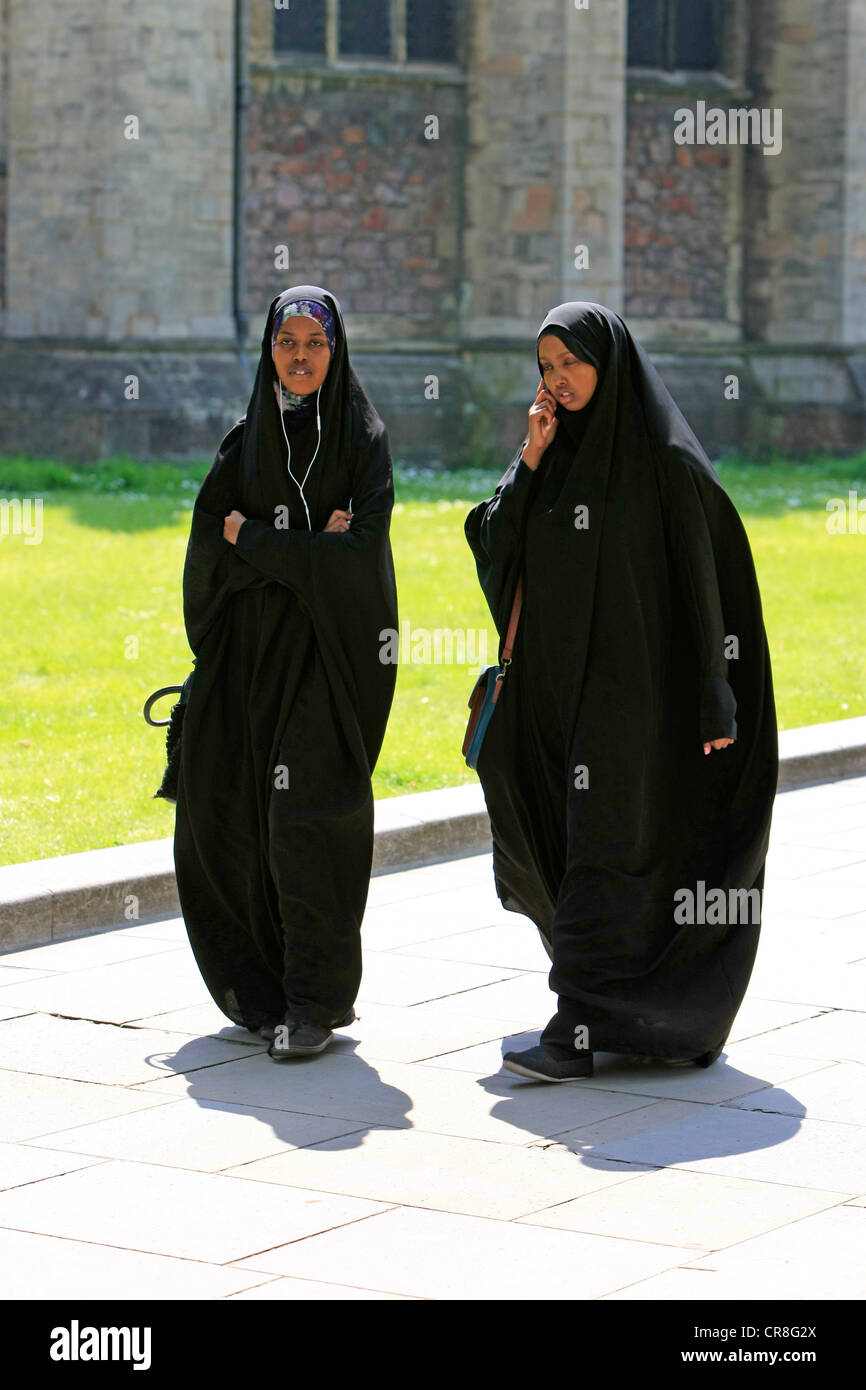 Two muslim women dressed in traditional Islamic clothing walk the ...