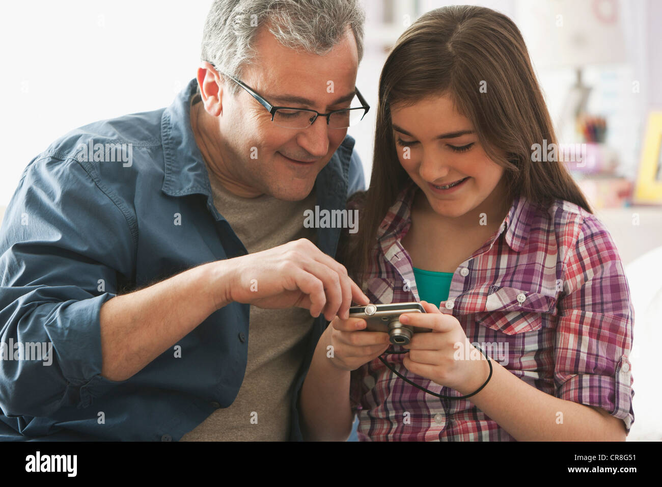 Mature man looking at digital camera with daughter Stock Photo - Alamy