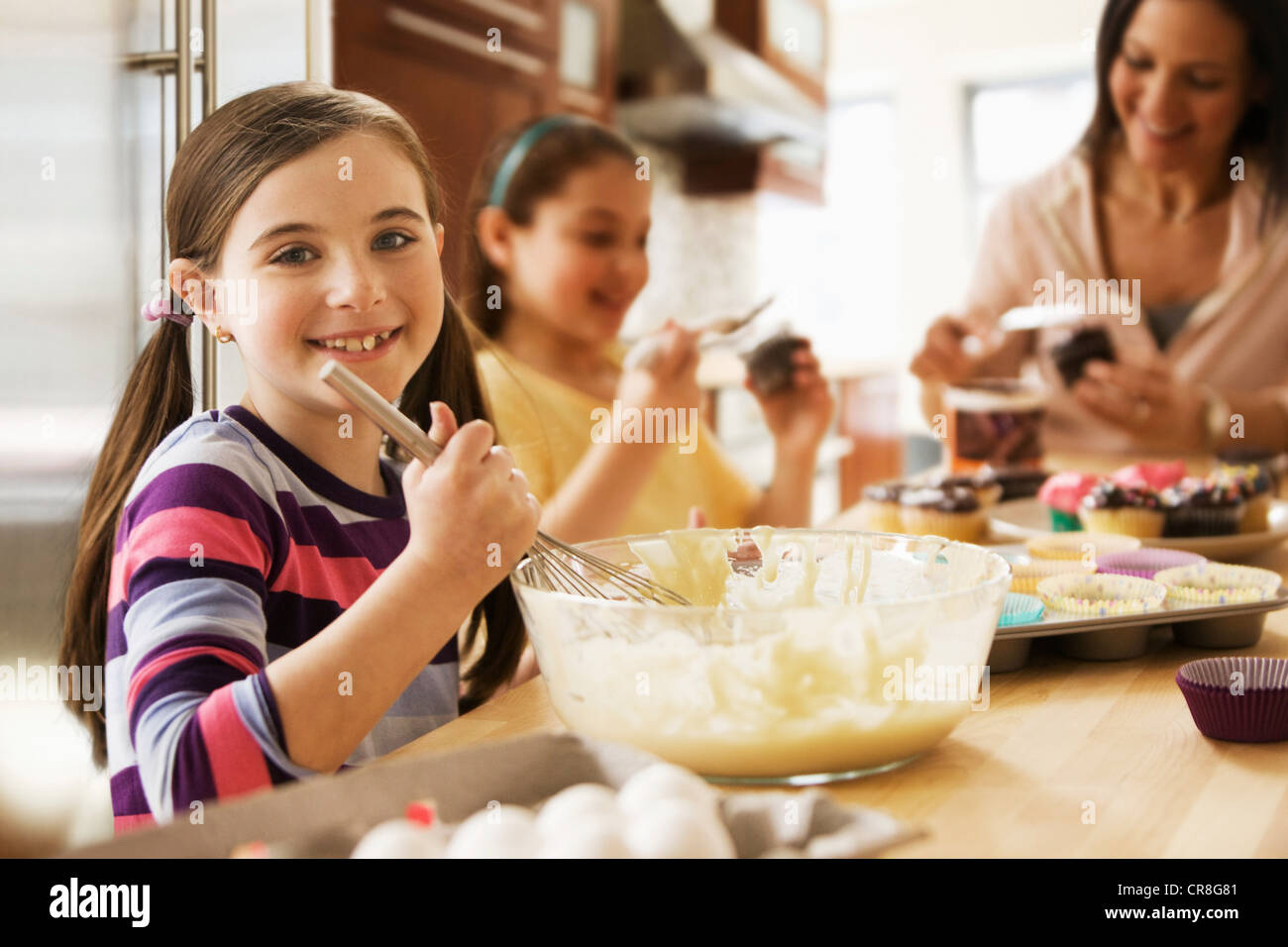 Portrait of girl making cakes with family in kitchen Stock Photo - Alamy