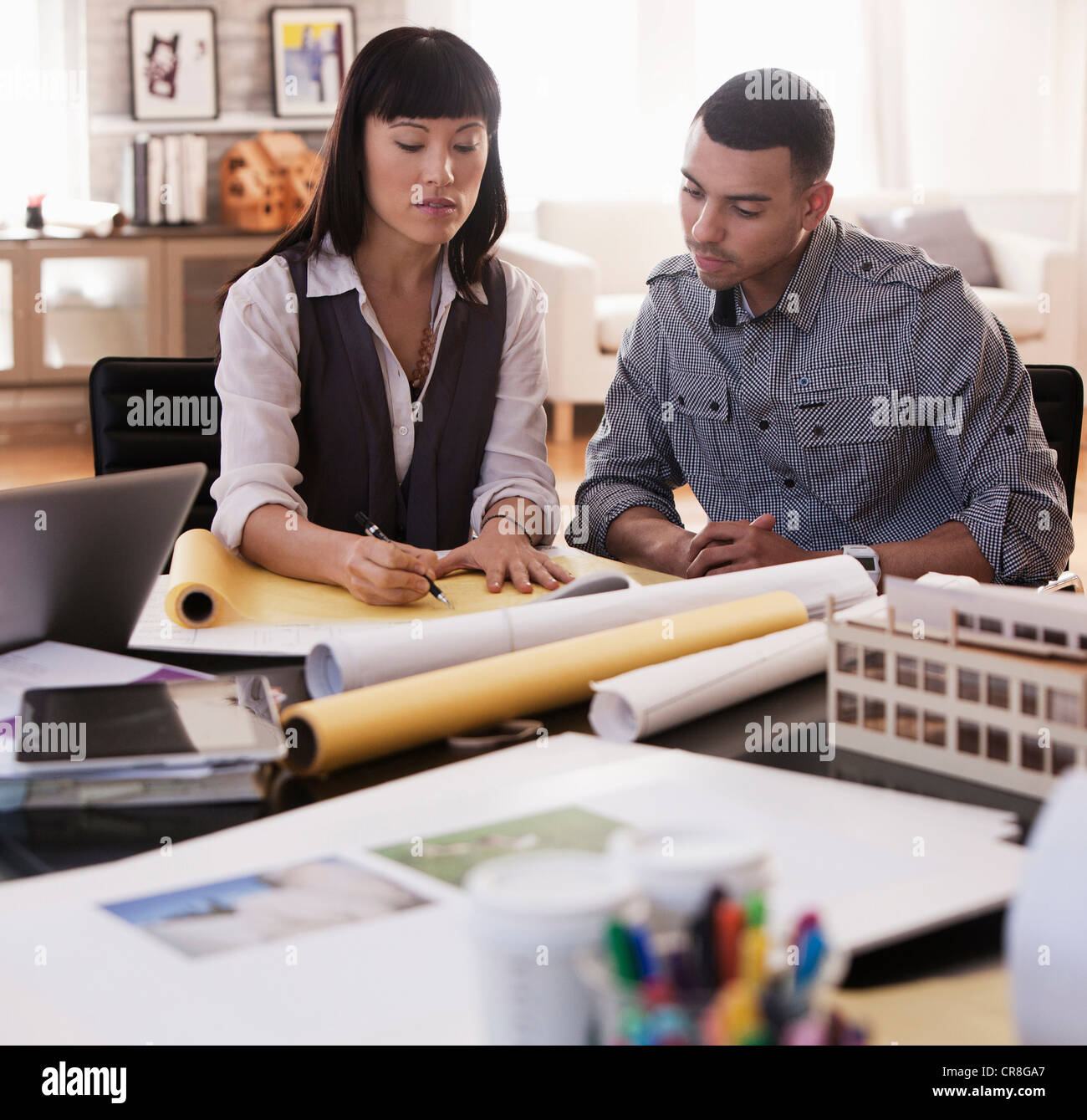 Architects discussing plans in studio Stock Photo - Alamy