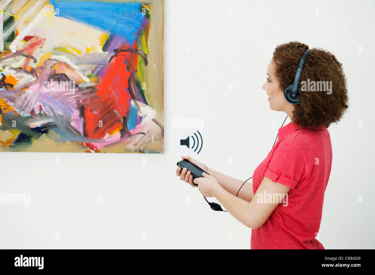 Young woman using audio guide in art gallery Stock Photo - Alamy