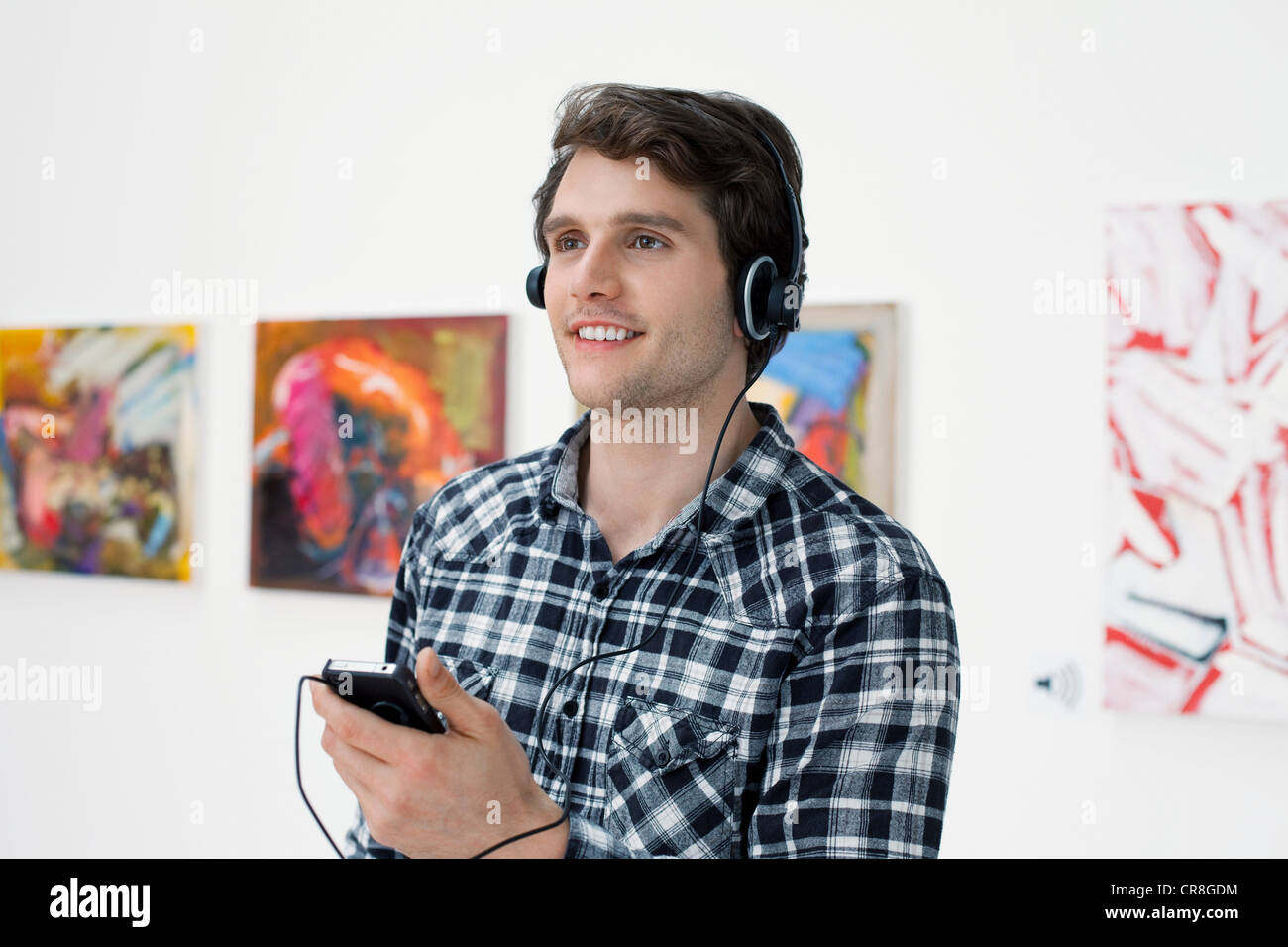 Young man using audio guide in art gallery Stock Photo - Alamy