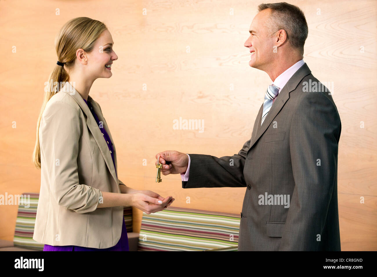 Estate agent giving keys to customer Stock Photo - Alamy