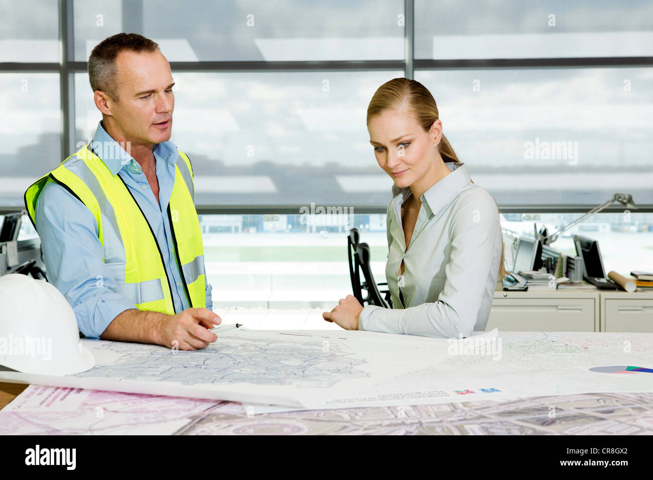 Engineer with architect looking at blueprints in office Stock Photo - Alamy