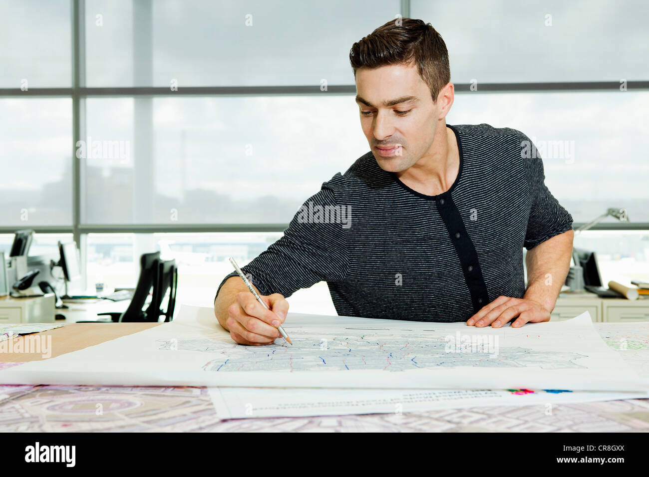 Architect working on blueprints in office Stock Photo - Alamy