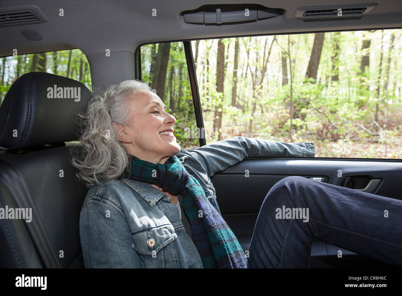 Senior woman relaxing in backseat of car Stock Photo - Alamy