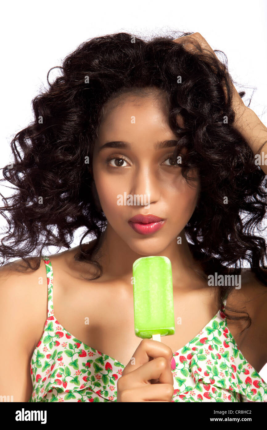 Young woman eating green popsicle, portrait Stock Photo - Alamy